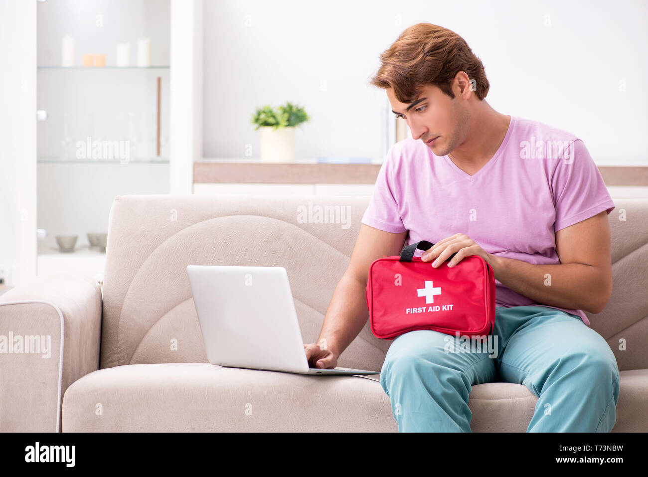 Sick man at home with first aid kit Stock Photo - Alamy