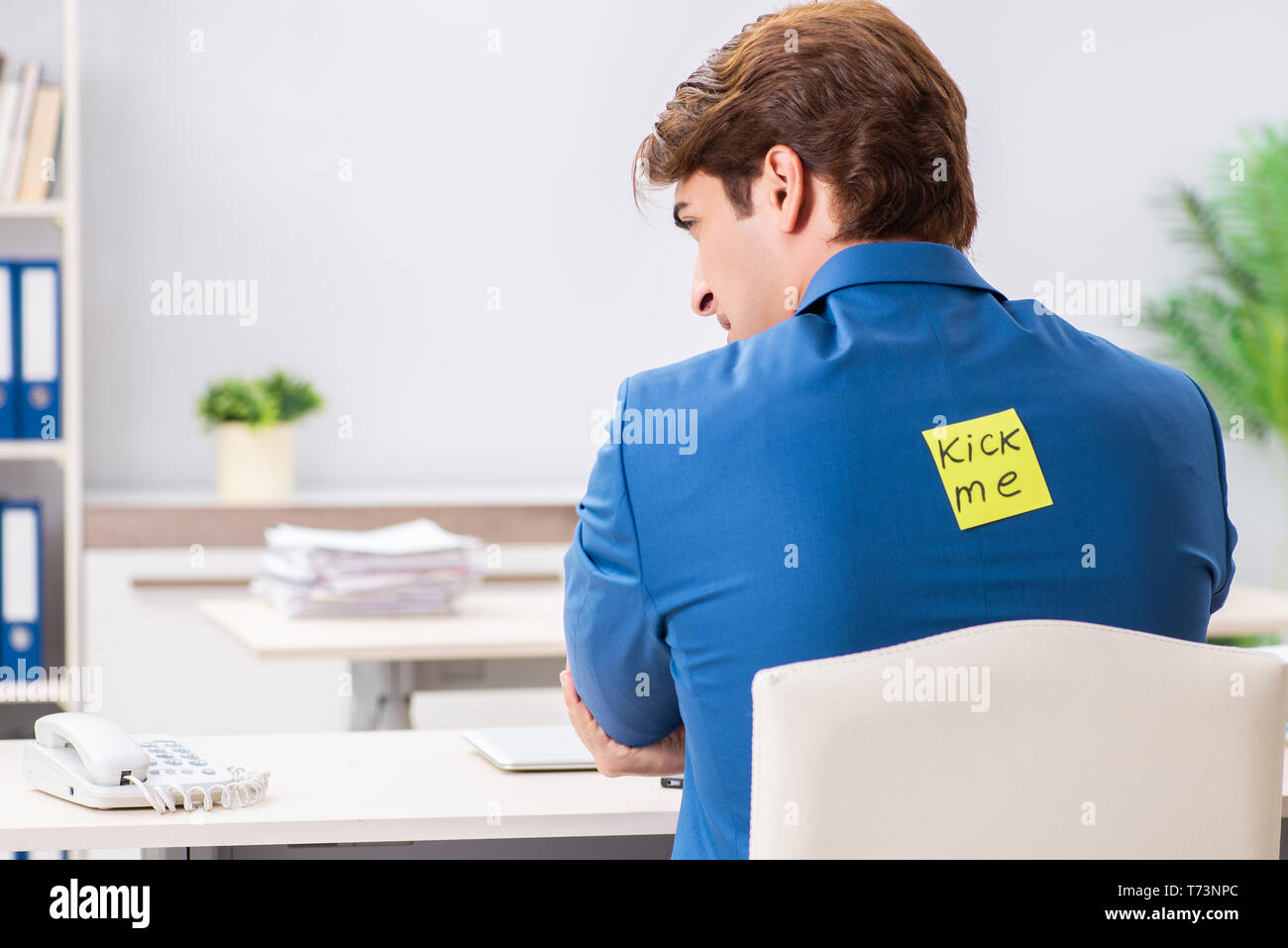 Office prank with kick me message on sticky note Stock Photo - Alamy