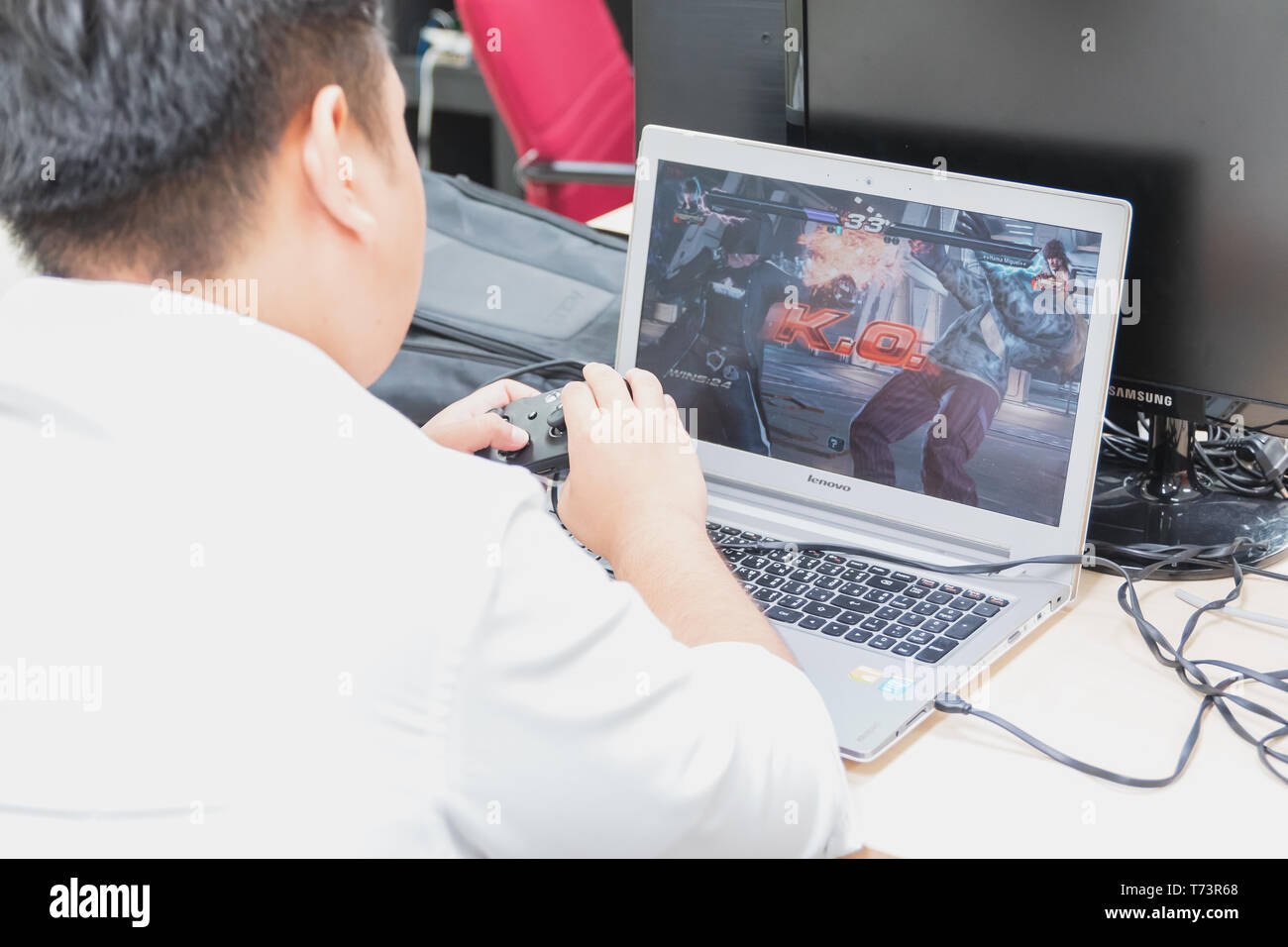 Back of Asian university student playing game in the classroom during ...