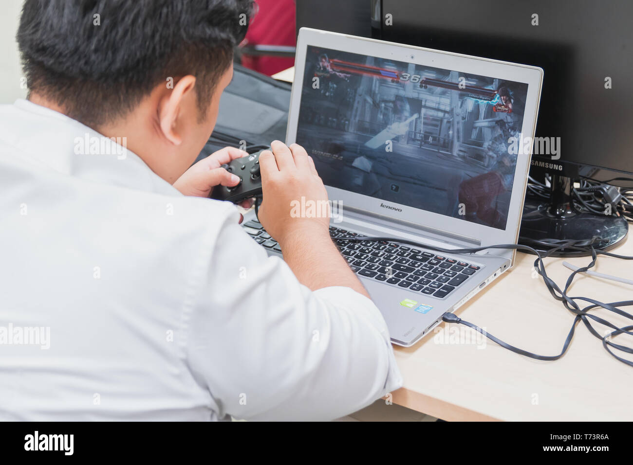Back of Asian university student playing game in the classroom during ...