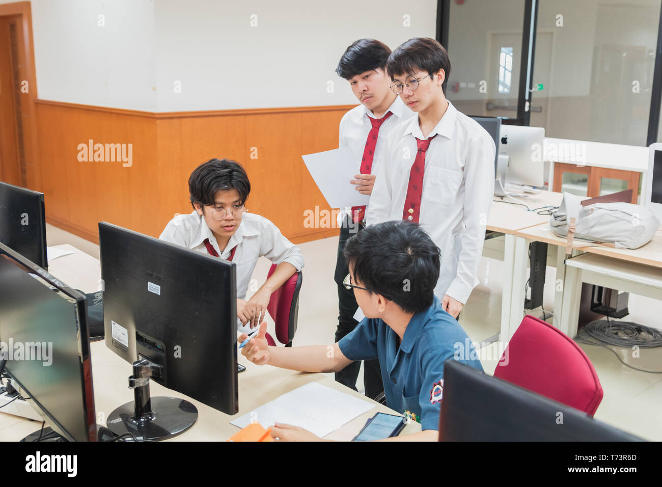 Group of Thai University Students discussing about their final computer ...