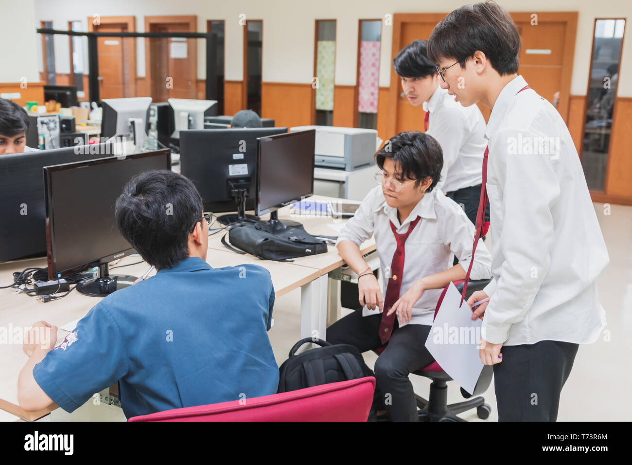 Group of Thai University Students discussing about their final computer ...