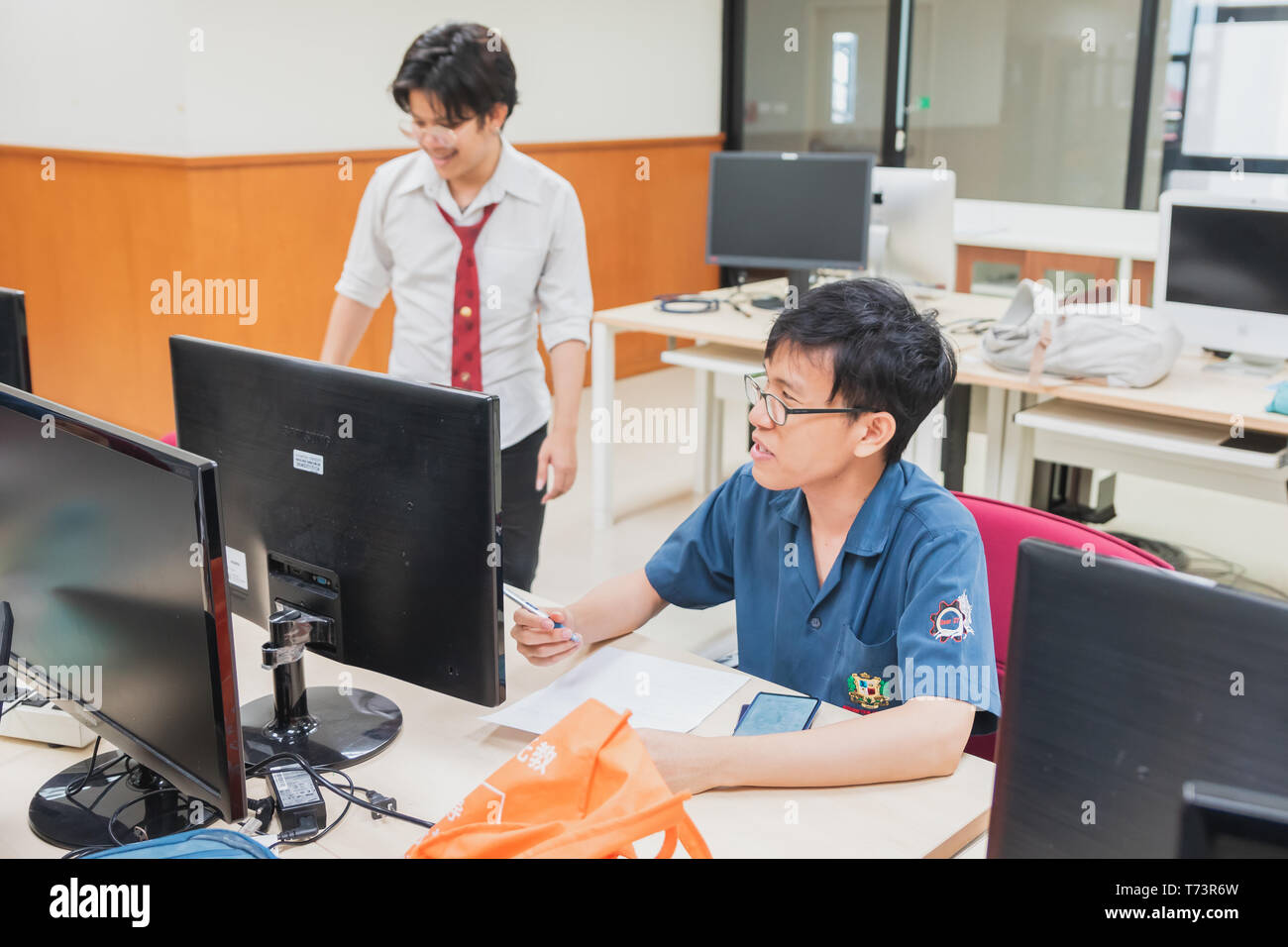 Group of Thai University Students discussing about their final computer ...