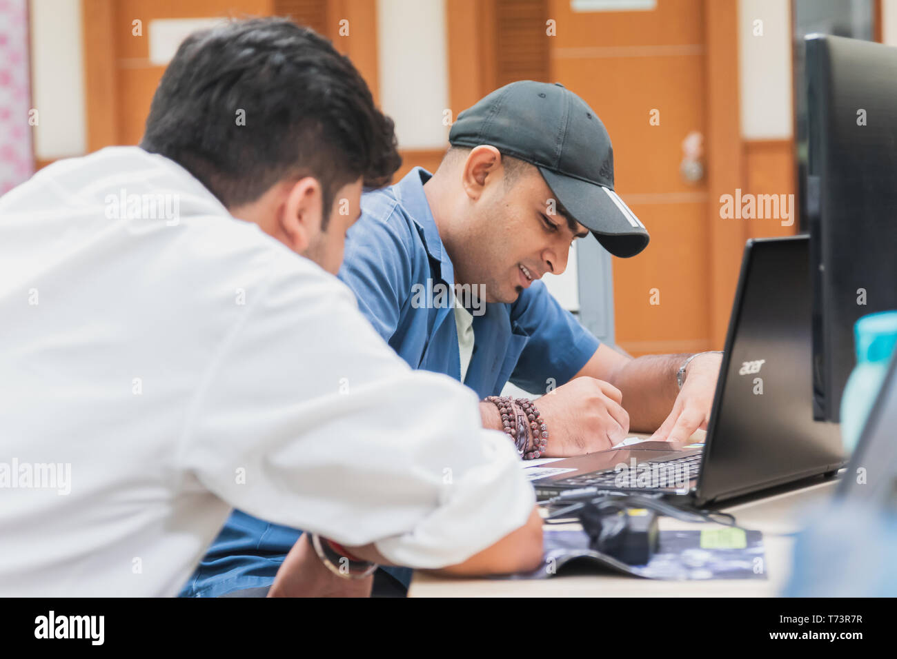 Two asian university student discuss about their assignment in a ...