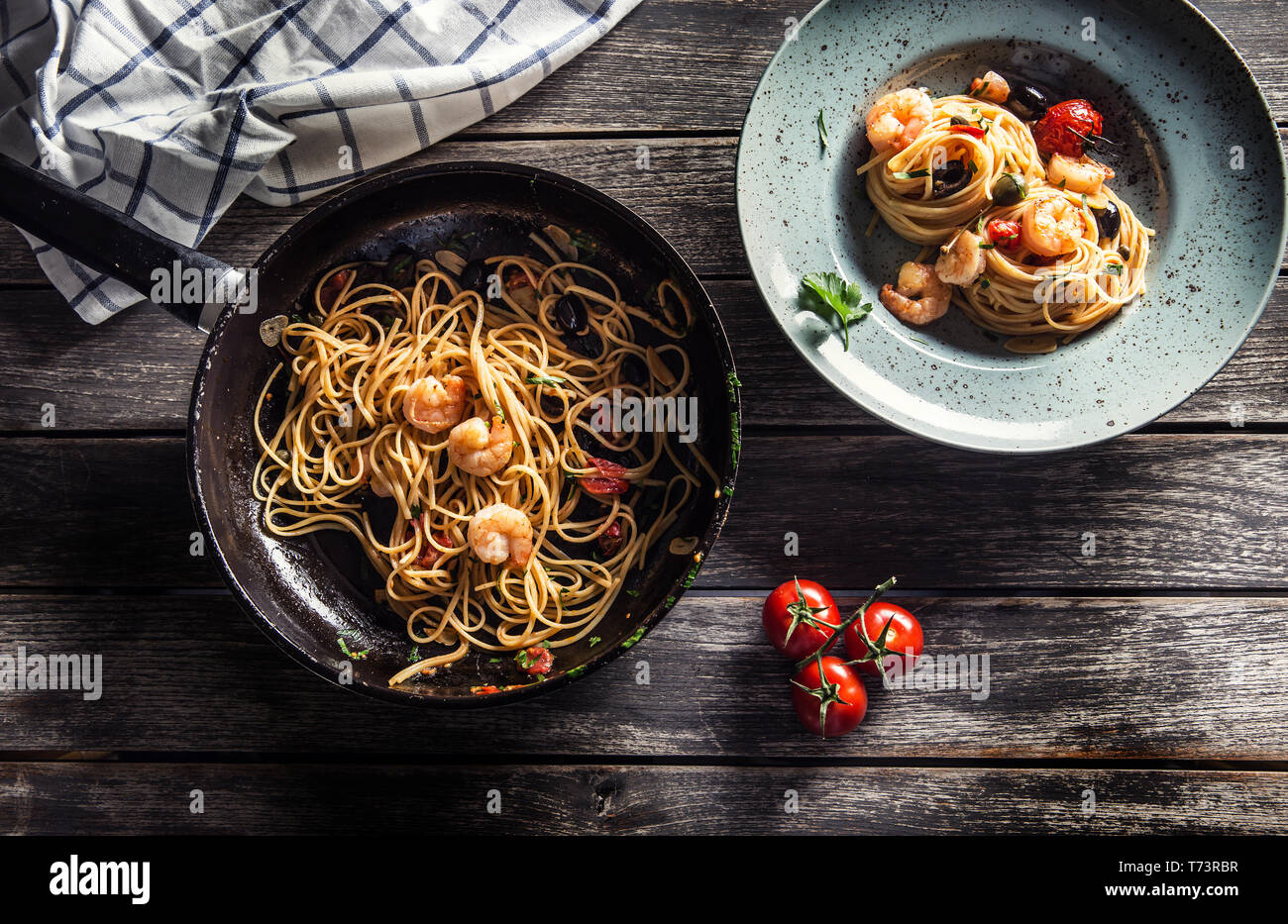 Pasta spaghetti on plate and pan with shrimp tomato sauce toatoes and ...