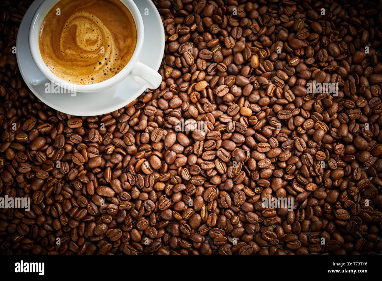 Roasted coffee bean background texture with vignette and cup of freshly ...