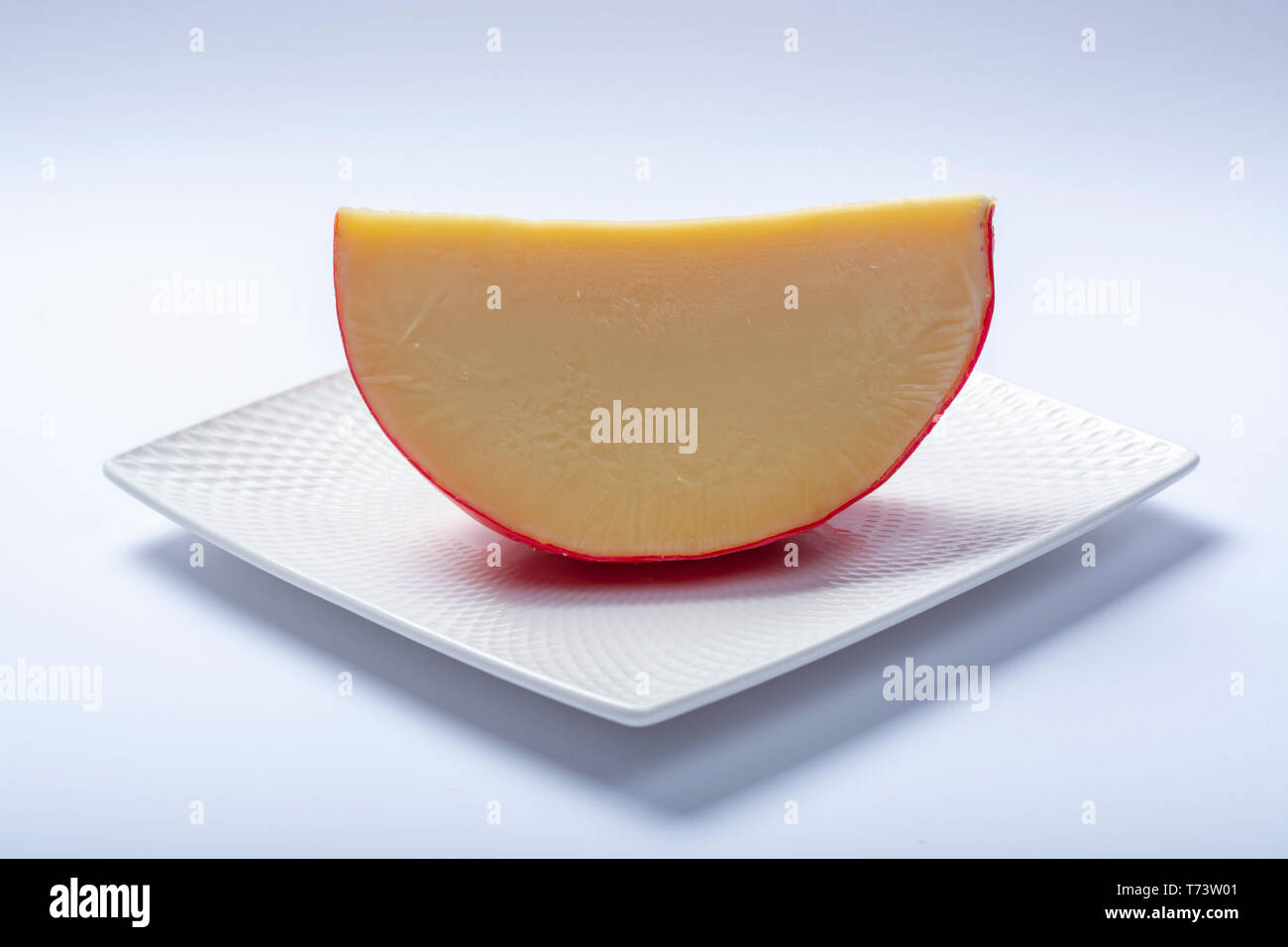 One piece of traditional Dutch red ball Edam cheese close up on white ...