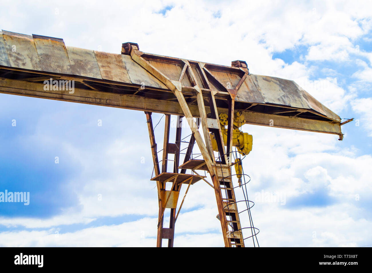 Old rusty gantry crane on blue sky background Stock Photo - Alamy