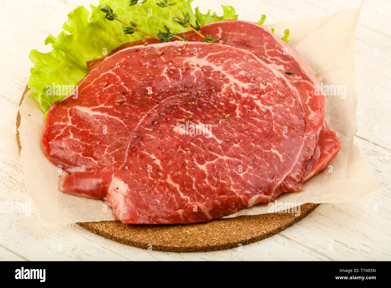 Raw beef schnitzel with spices ready for griil Stock Photo - Alamy