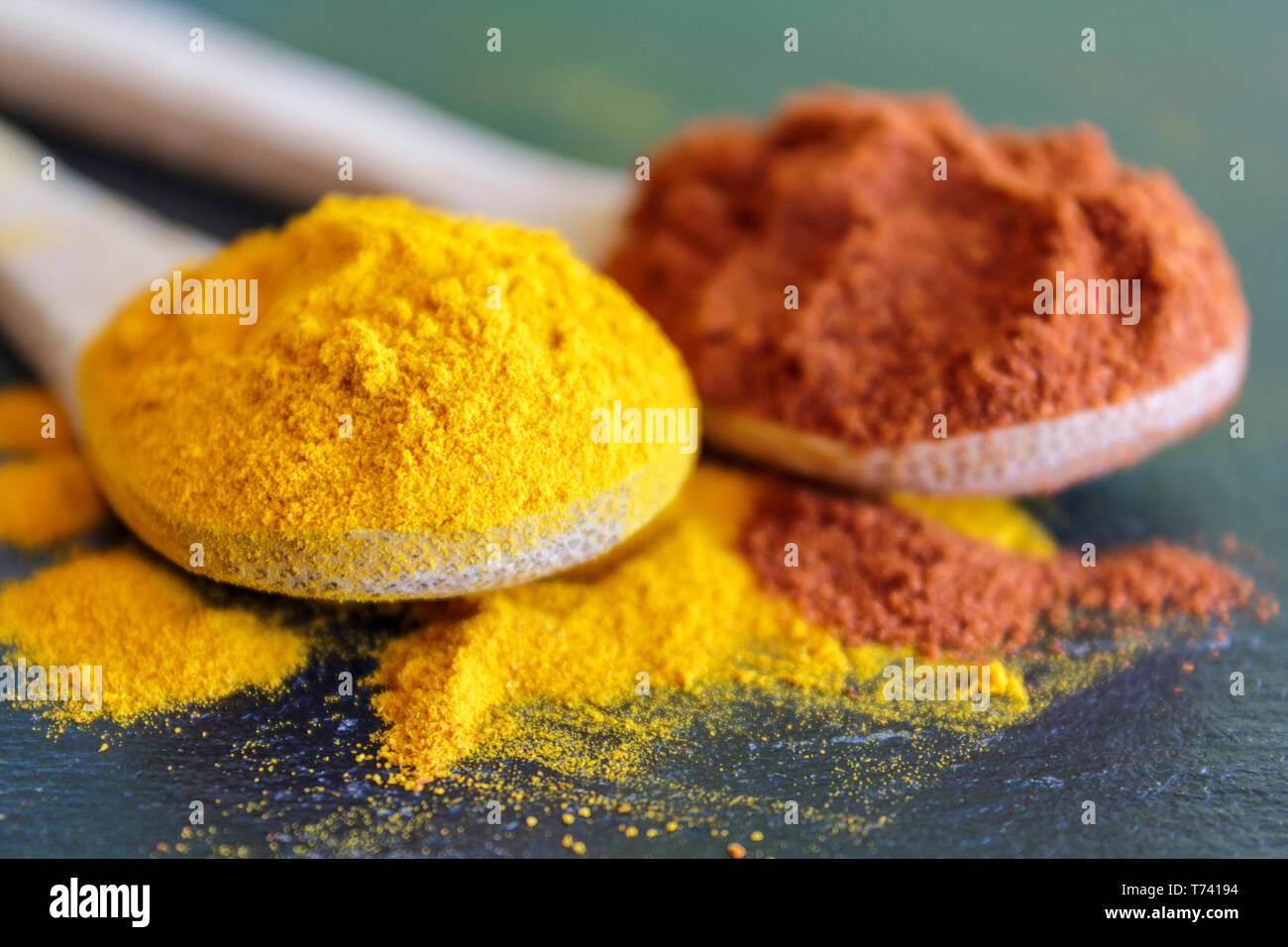 Wooden spoons with colorful exotic spices: cayenne pepper and turmeric ...