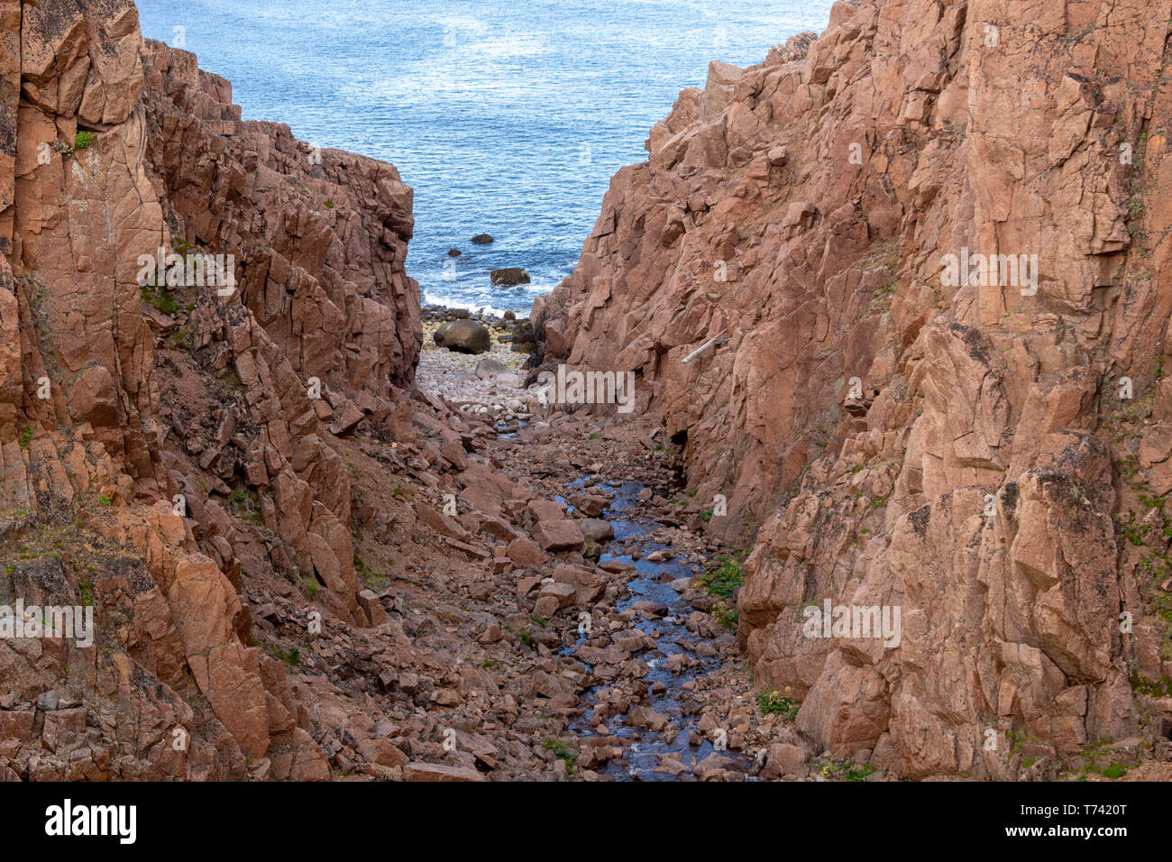river meets ocean along a rocky shoreline with heavy water flow in a ...
