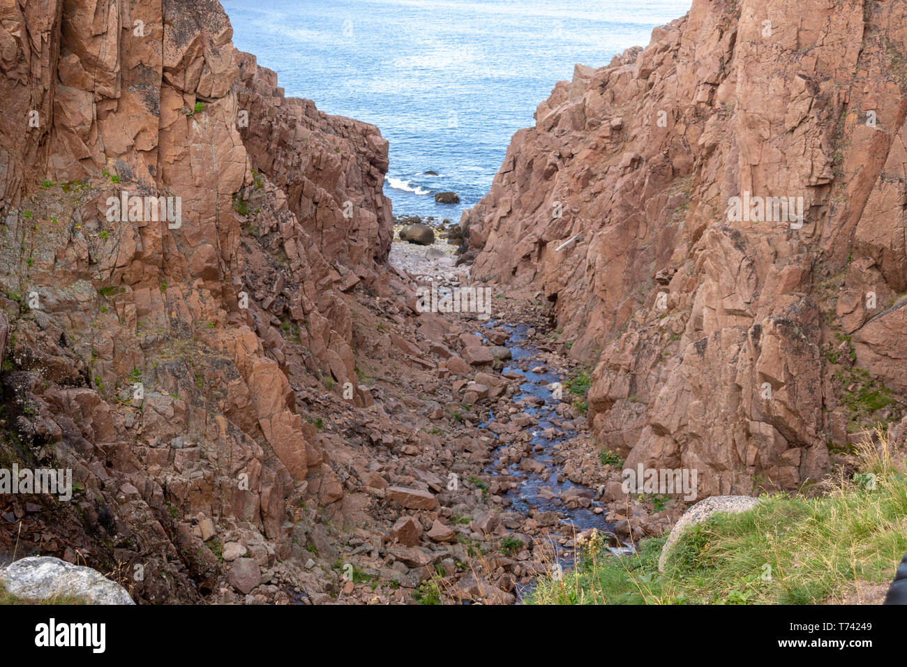 river meets ocean along a rocky shoreline with heavy water flow in a ...