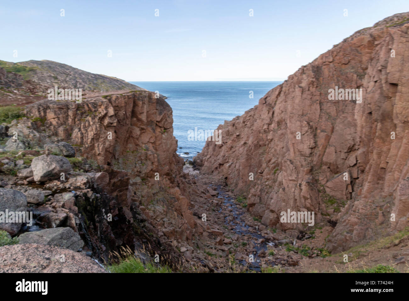 river meets ocean along a rocky shoreline with heavy water flow in a ...
