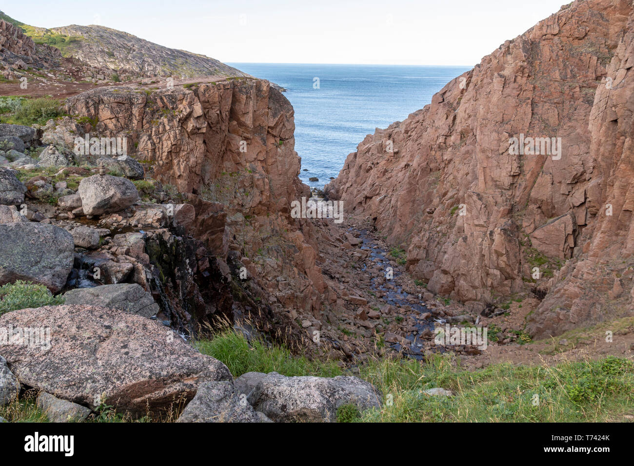 river meets ocean along a rocky shoreline with heavy water flow in a ...