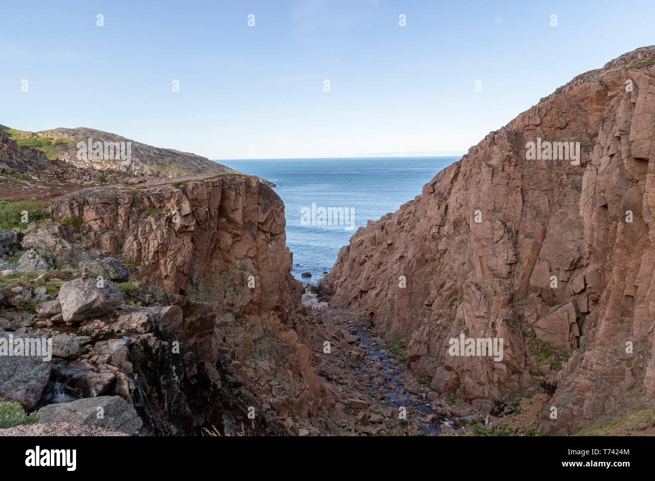river meets ocean along a rocky shoreline with heavy water flow in a ...