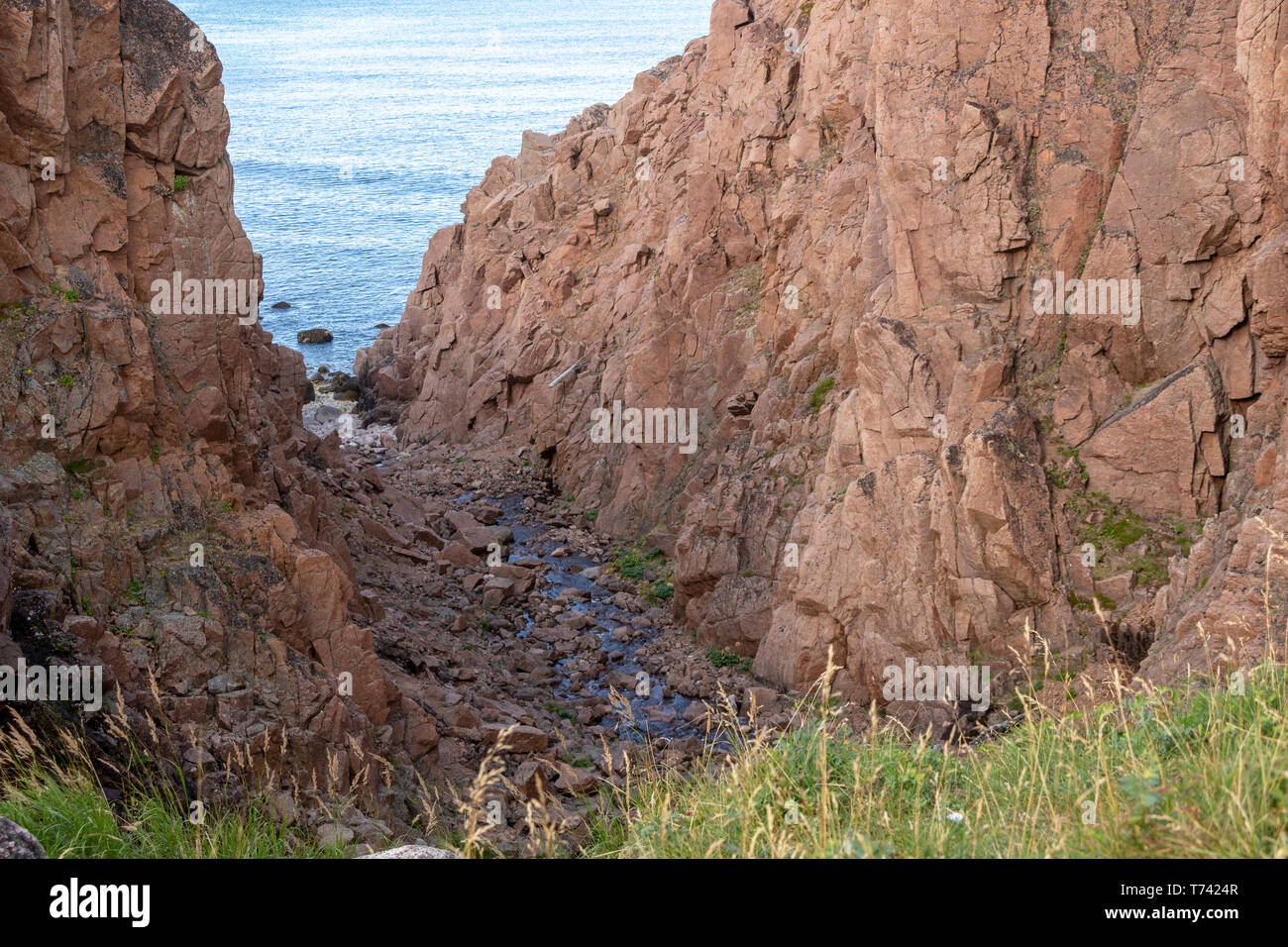 river meets ocean along a rocky shoreline with heavy water flow in a ...
