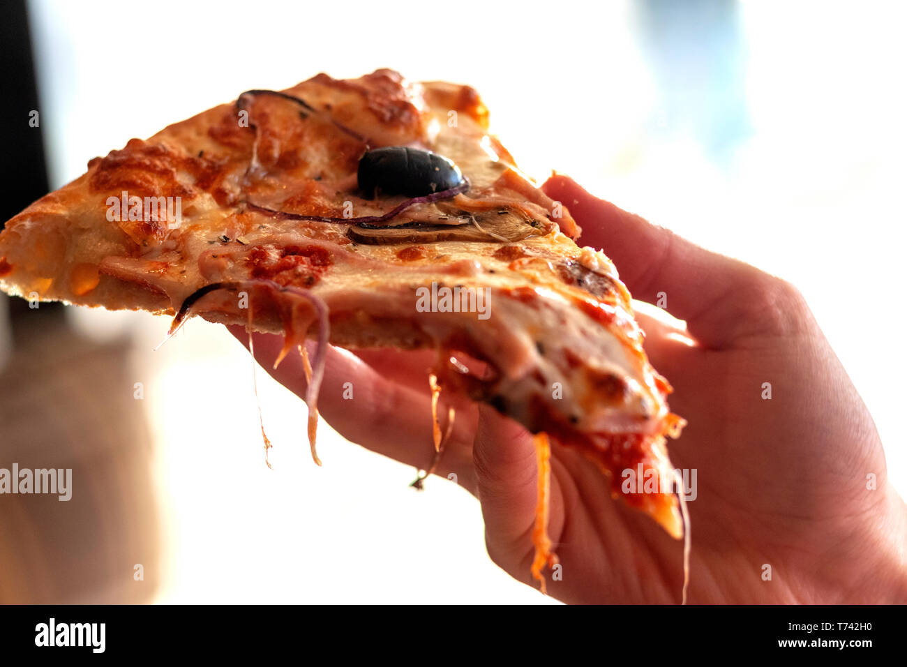 Hand taking slice of delicious pizza Stock Photo - Alamy