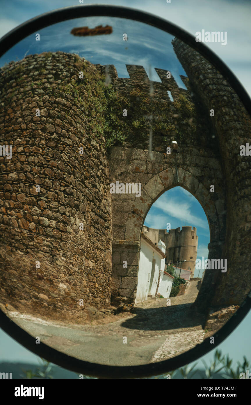 Stone tower at the main entrance doorway reflected in a street mirror ...