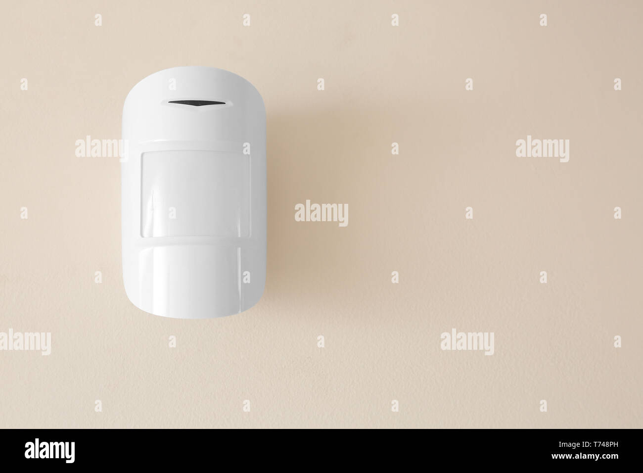 Modern motion sensor on wall indoors Stock Photo - Alamy