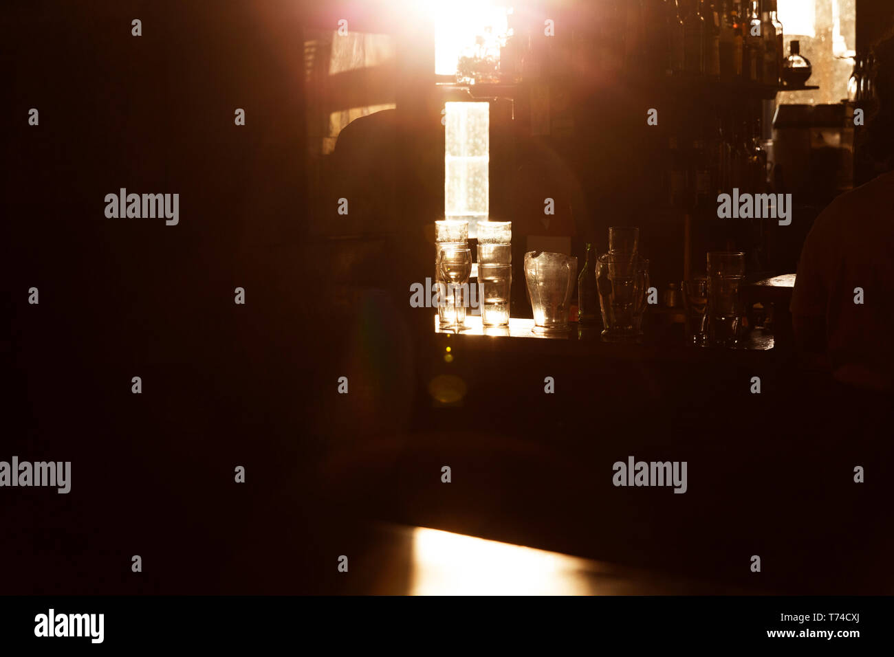 Sun beaming through vintage bar window directly through empty beer ...