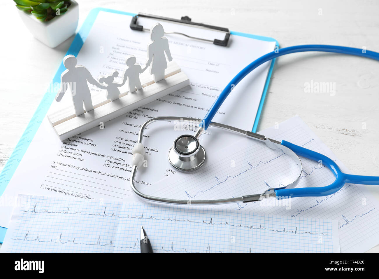 Composition with family figure and stethoscope on wooden table. Health ...