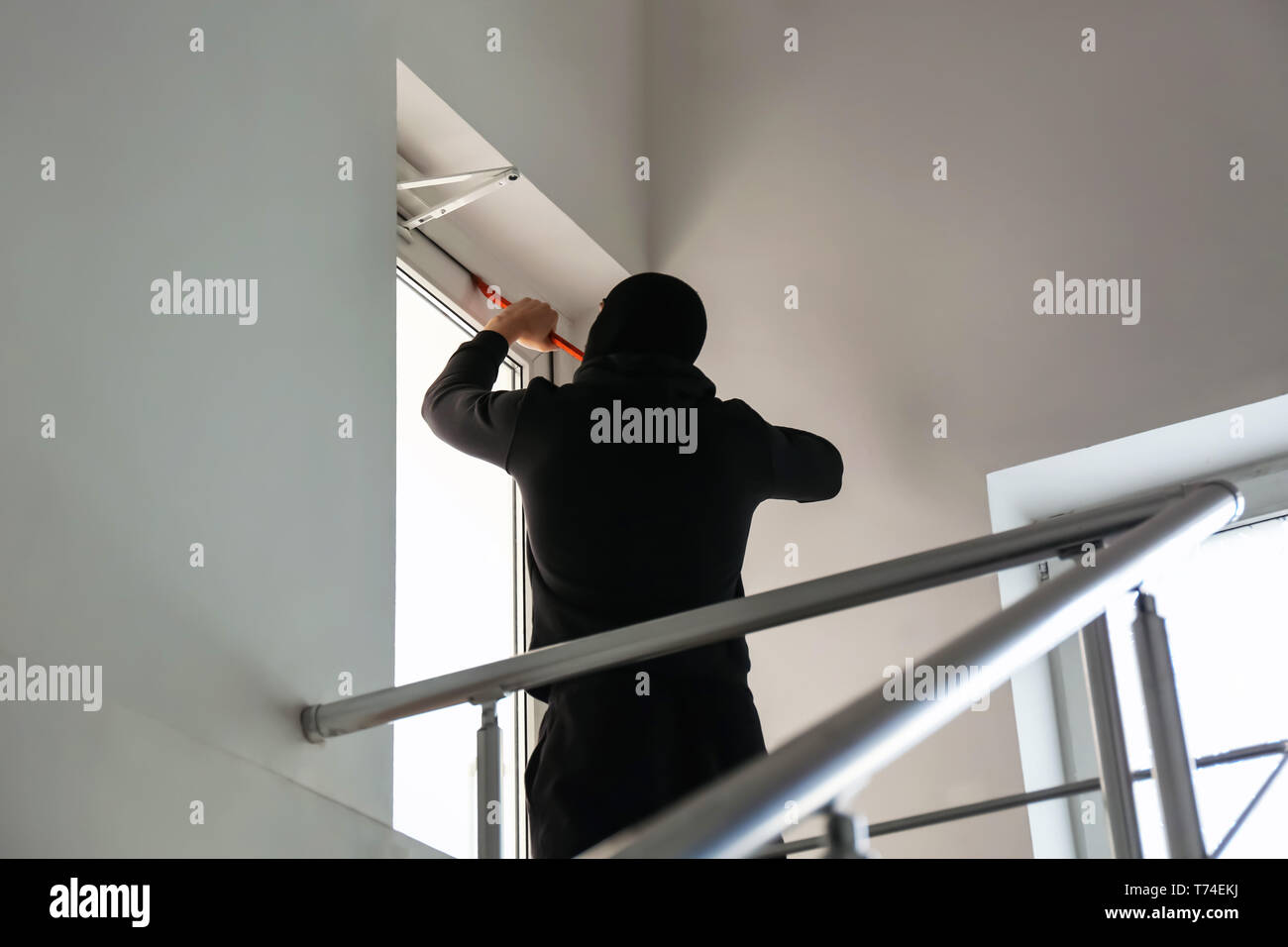 Male thief breaking door with crowbar indoors Stock Photo - Alamy