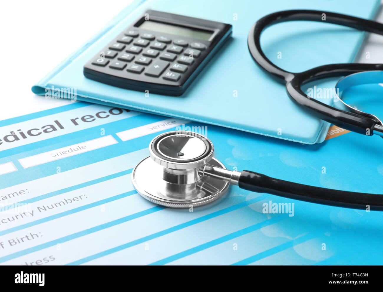 Stethoscope with medical record and calculator on white background ...