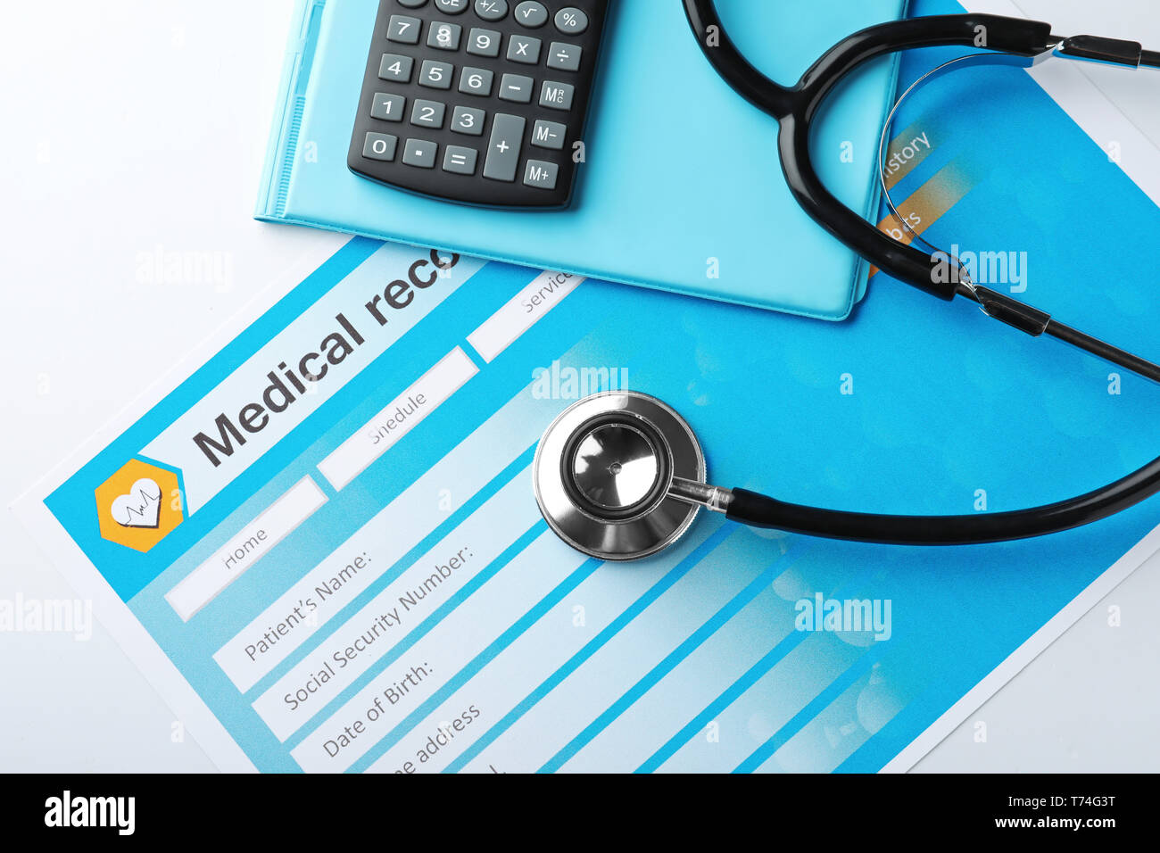 Stethoscope with medical record and calculator on white background ...
