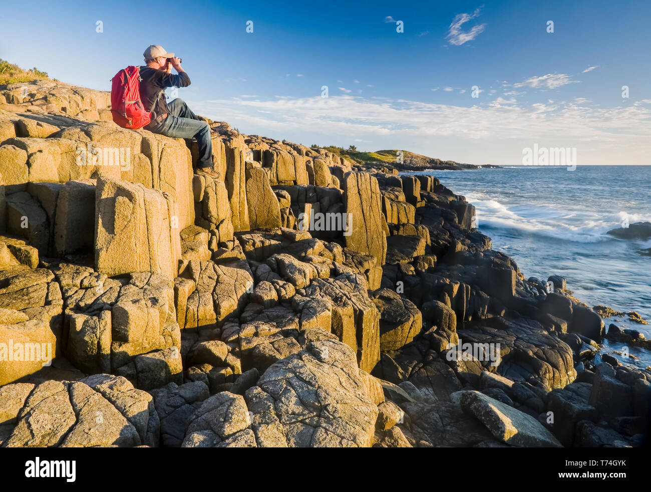 Hiker on basalt rock cliffs, Dartmouth Point, Bay of Fundy; Long Island ...