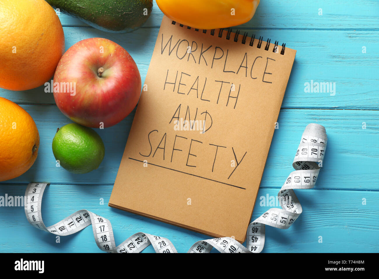 Words "Workplace, health and safety" written in notebook, fruits and ...