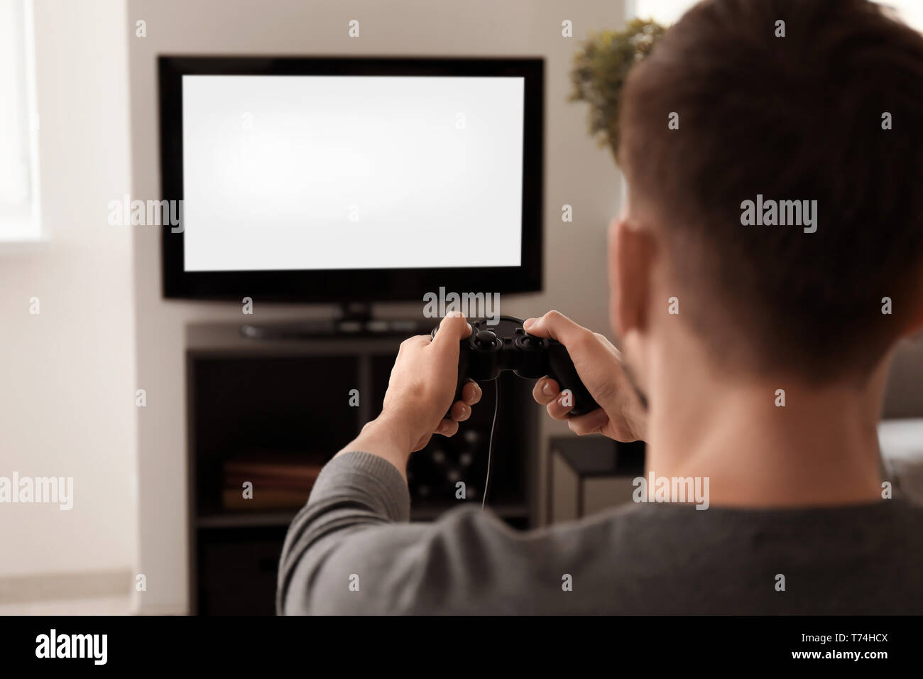 Man playing video game at home Stock Photo - Alamy