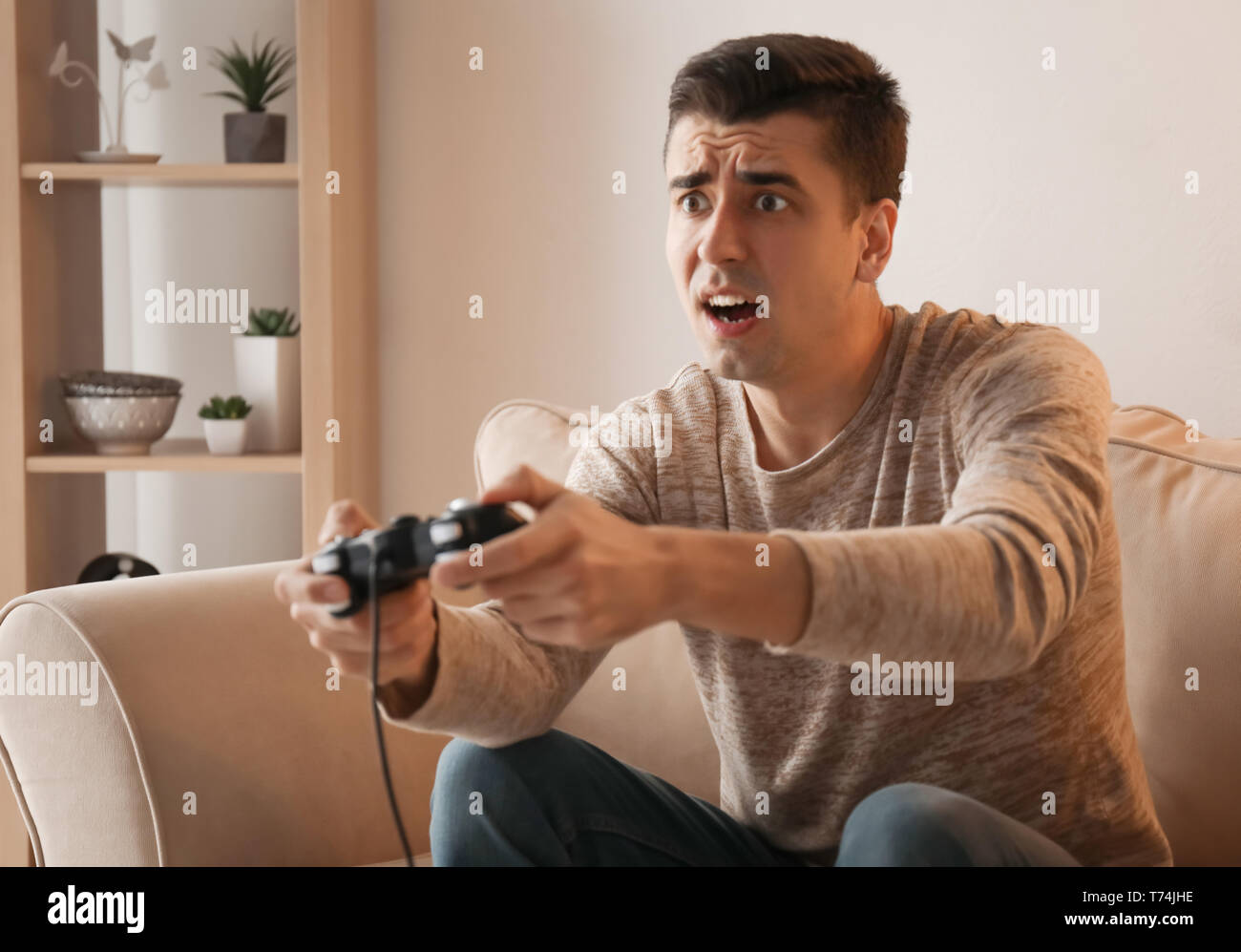 Young man playing video game at home Stock Photo - Alamy