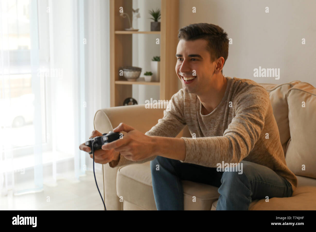 Young man playing video game at home Stock Photo - Alamy