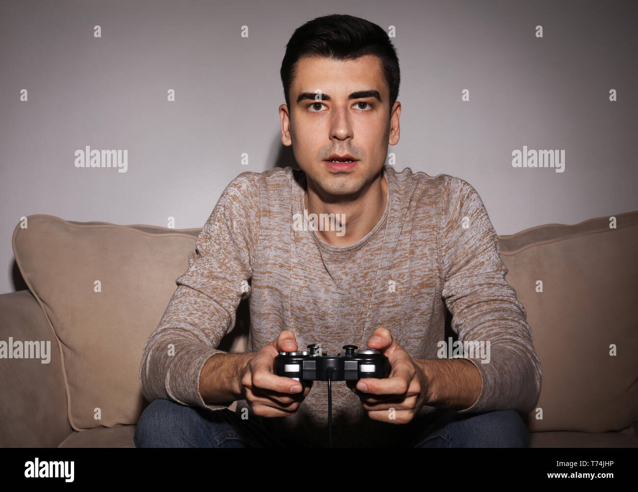 Young man playing video game at home in the evening Stock Photo - Alamy