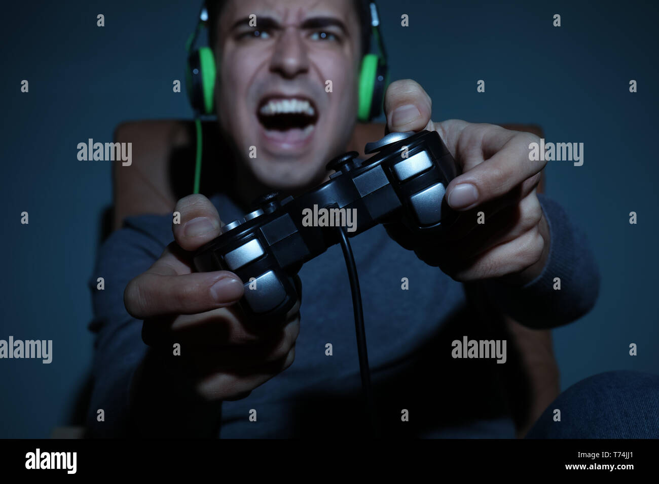 Young man playing video game at home in the evening Stock Photo - Alamy