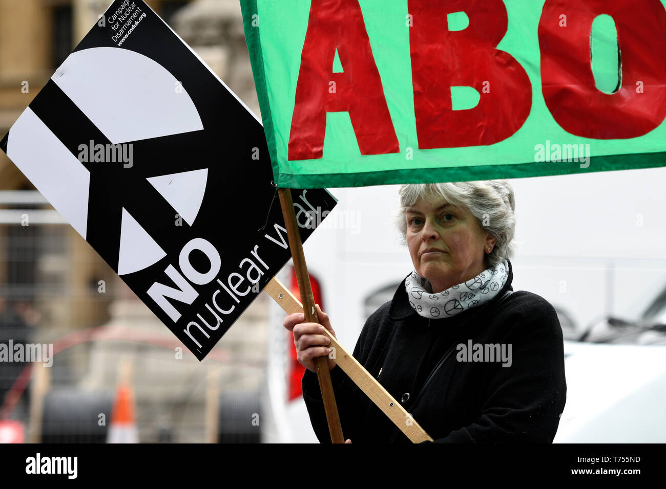 Activist seen holding a placard and a banner during the protest. Anti ...