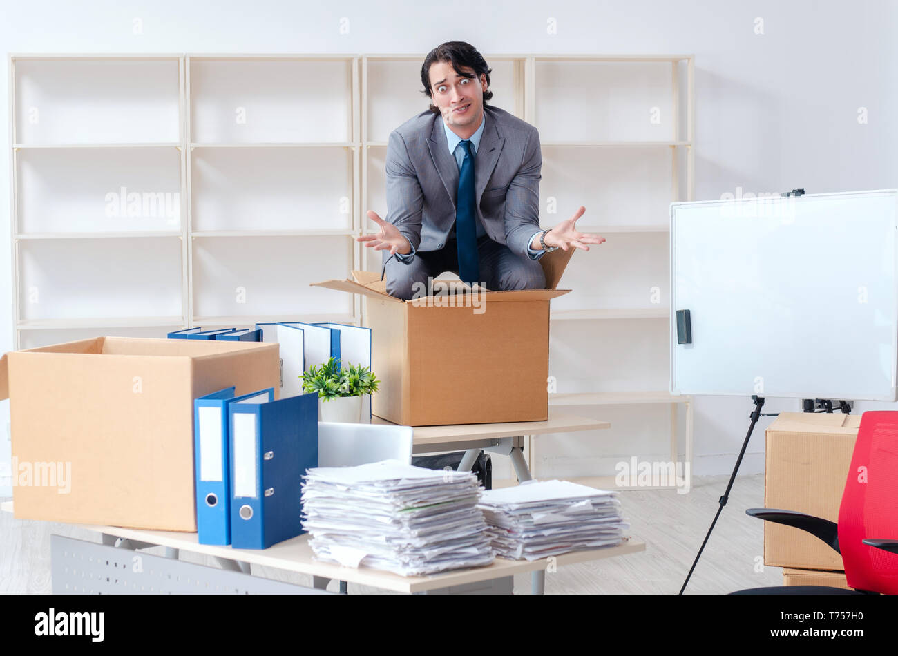 Young man employee with boxes in the office Stock Photo - Alamy