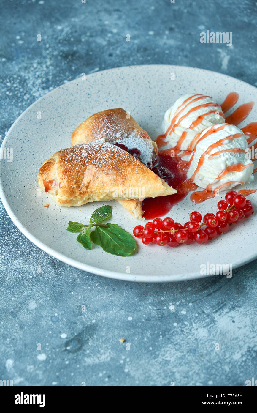 Sliced homemade berry strudel served with fresh red currant berries and ...