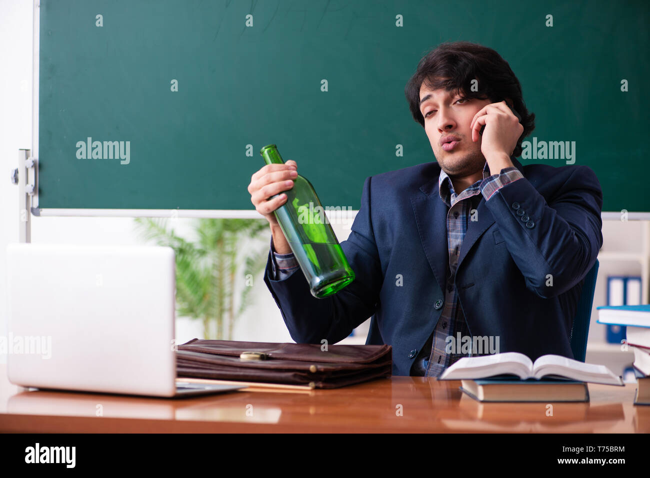 Male teacher drinking in the classroom Stock Photo - Alamy