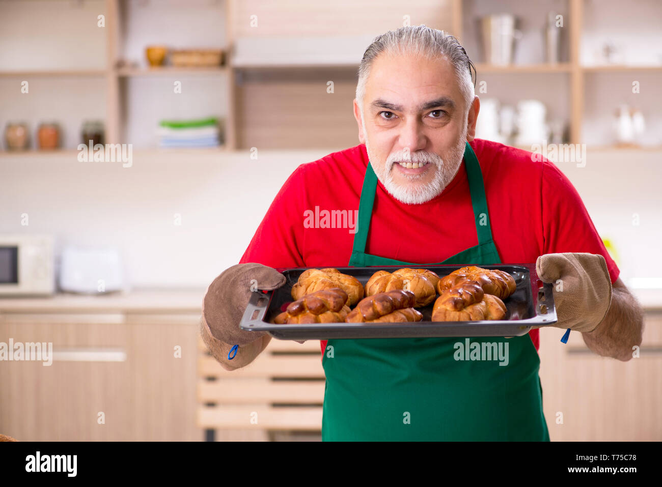 Old male baker working in the kitchen Stock Photo - Alamy