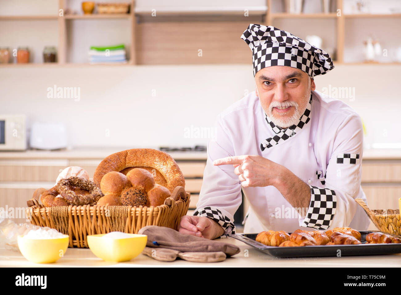Old male baker working in the kitchen Stock Photo - Alamy