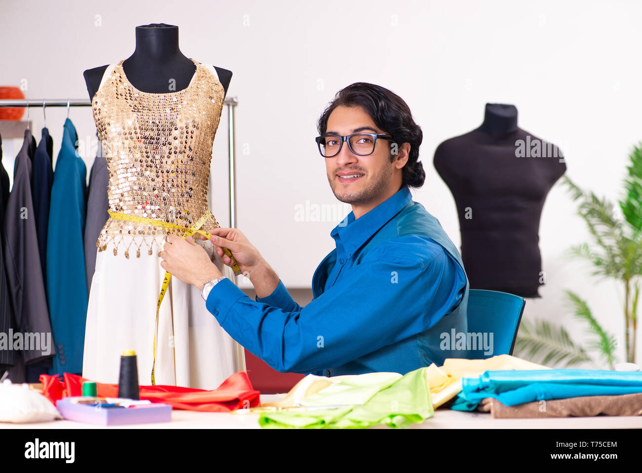 Young male tailor working at workshop Stock Photo - Alamy