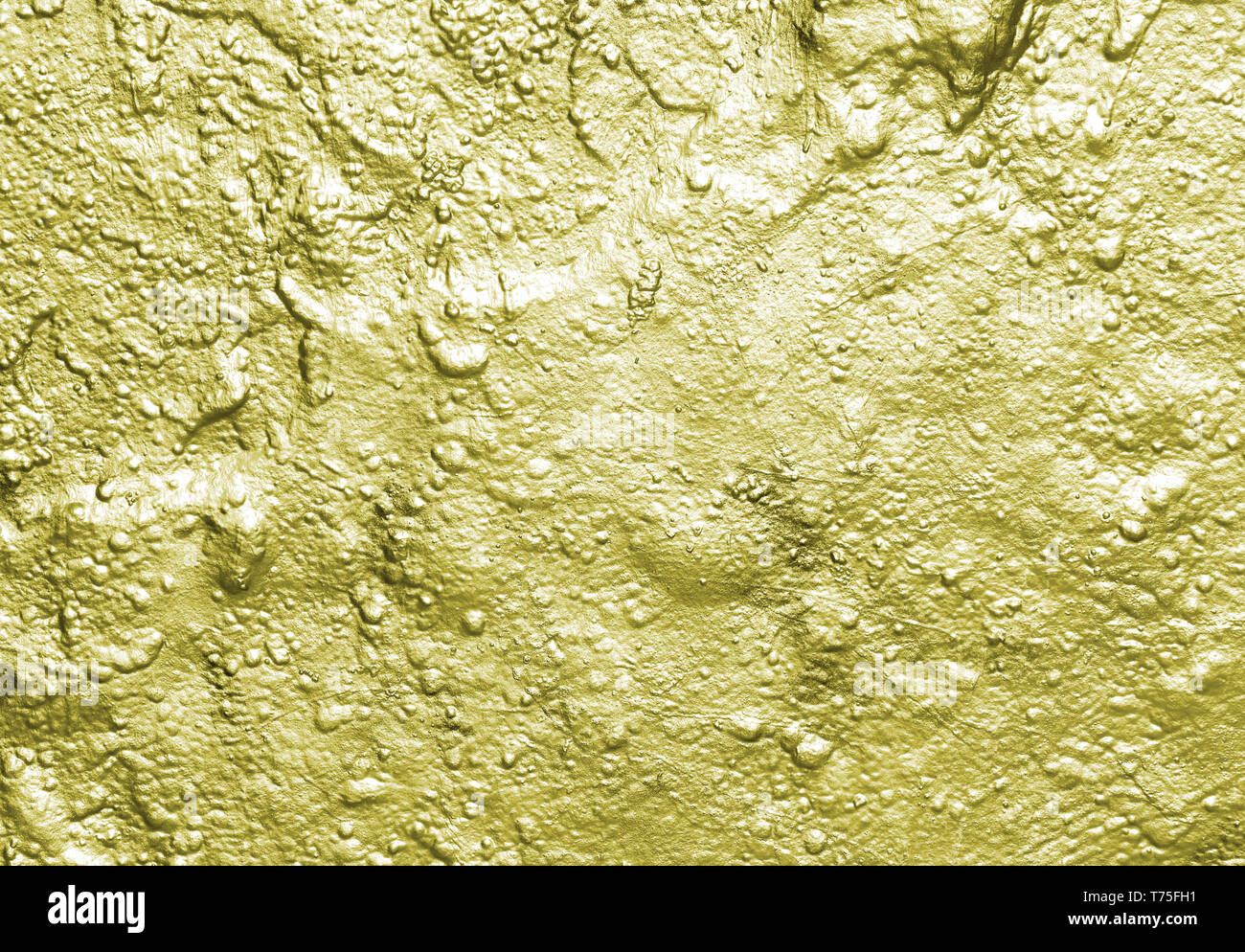 Rough colored wall with very shiny yellow golden effect metallic paint ...