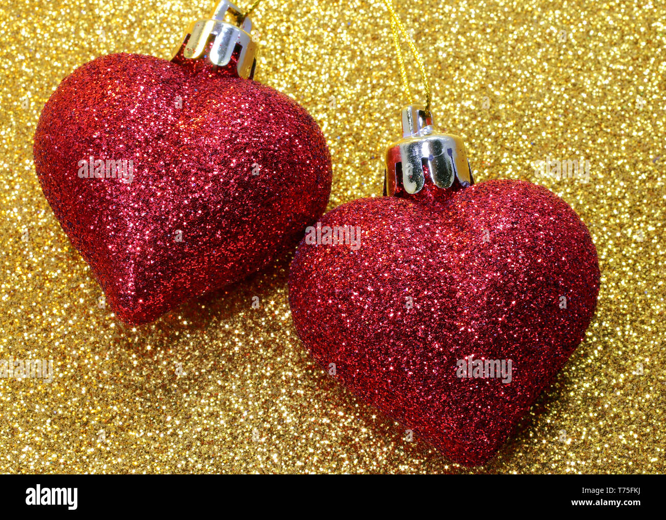 two big red hearts on golden background Stock Photo - Alamy