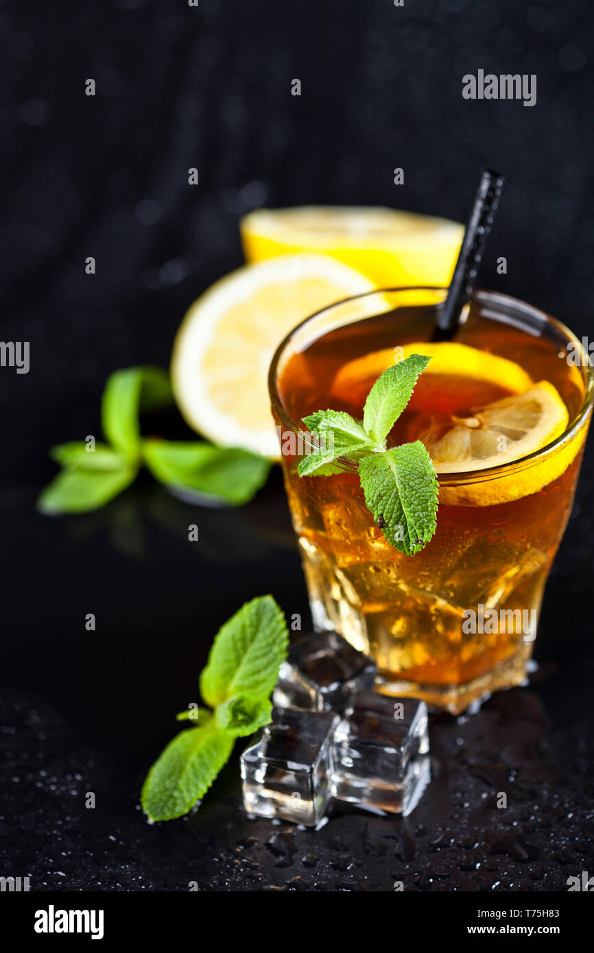 Traditional iced tea with lemon, mint leaves and ice cubes in glass on ...