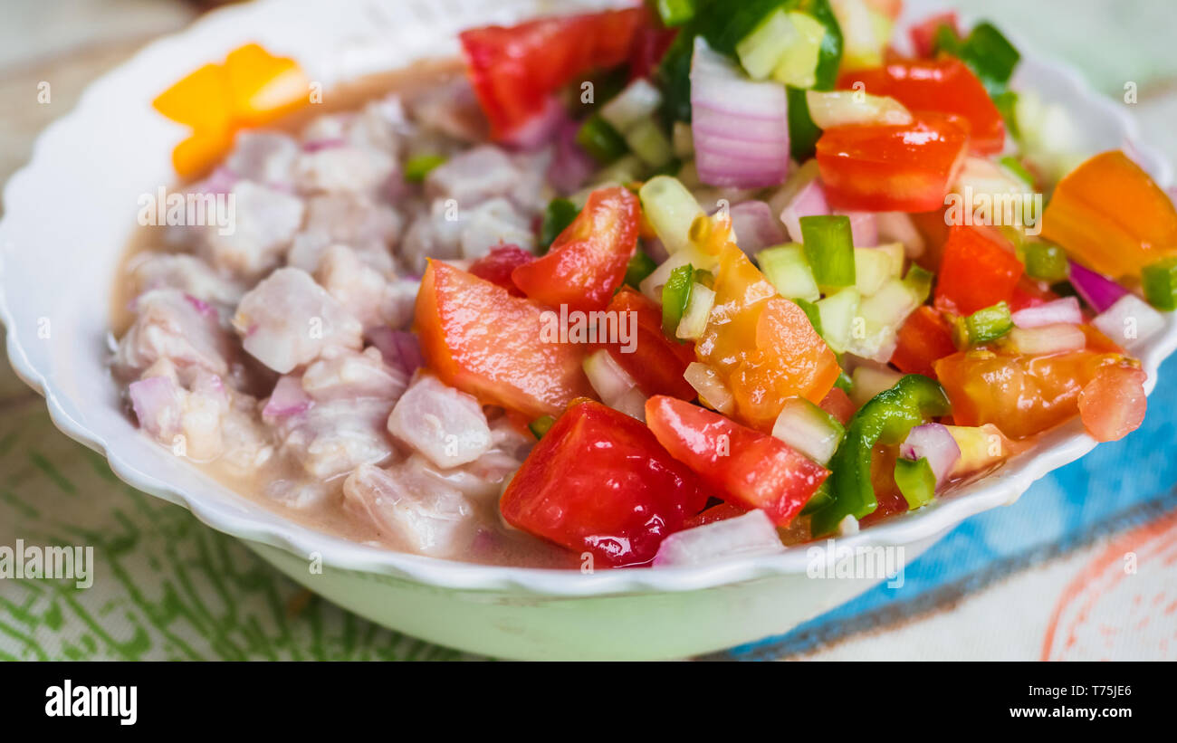 Typical raw fish dish, ceviche. With vegetables, onion, red and green ...