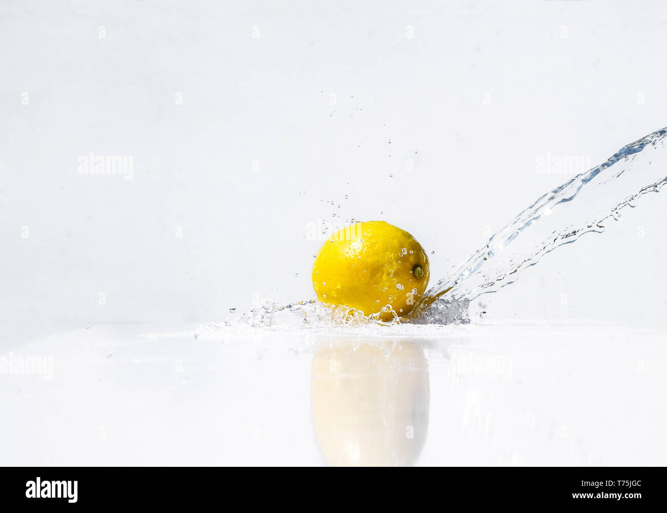 Yellow lemon in water splash on white background Stock Photo - Alamy