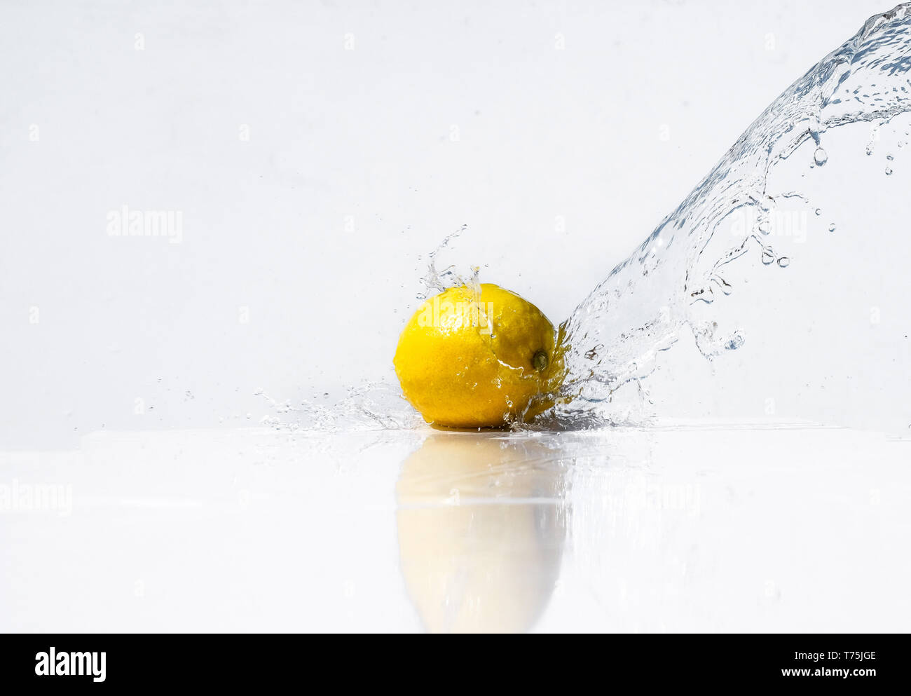 Yellow lemon in water splash on white background Stock Photo - Alamy