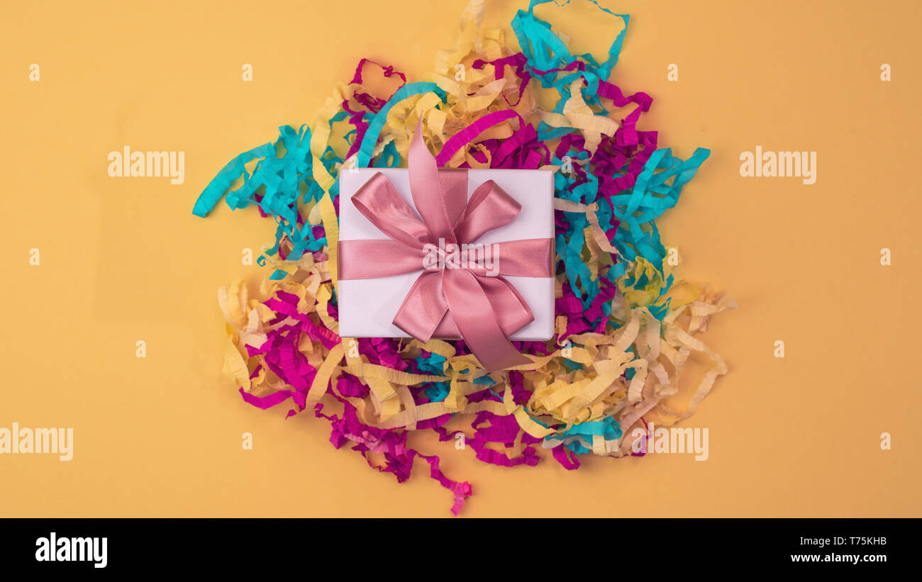 Banner Gift box with colored streamers bright yellow background. A top ...