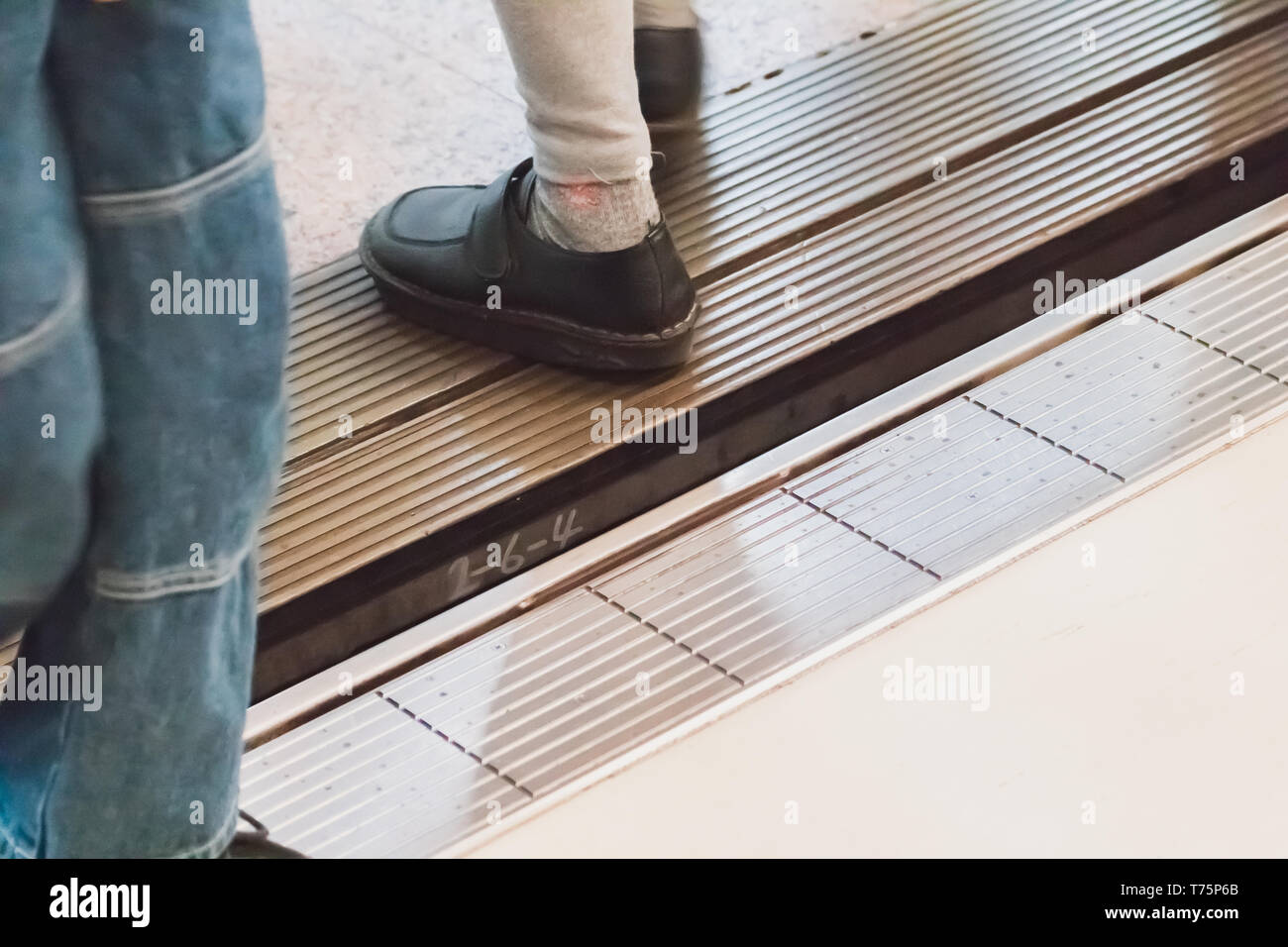 Close up people feet walking over the gap between a metro train and ...